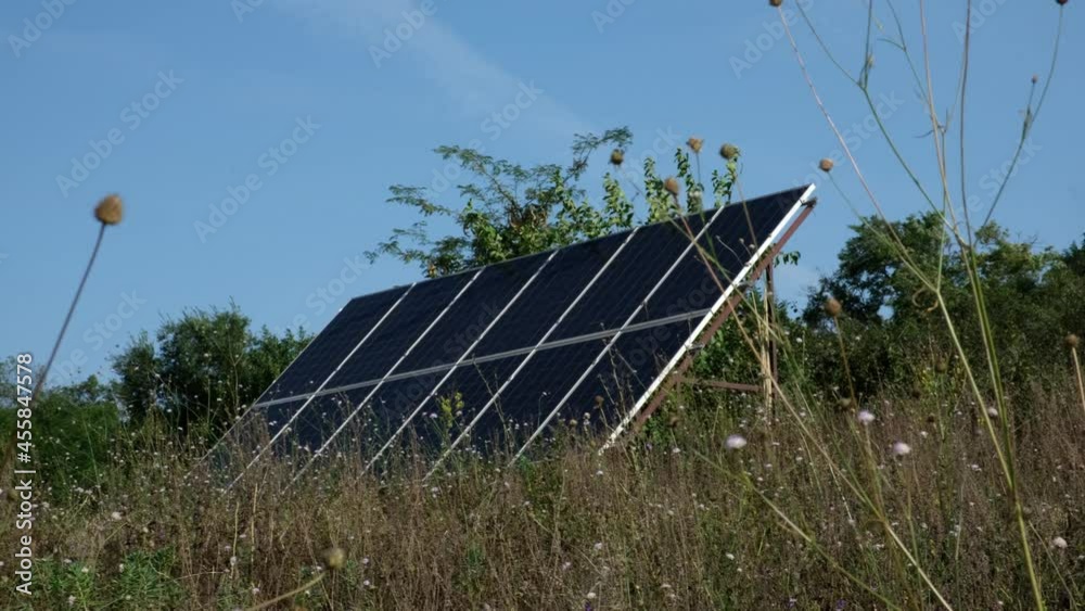 Solar panels in the field surrounded by grass and trees, close-up ...