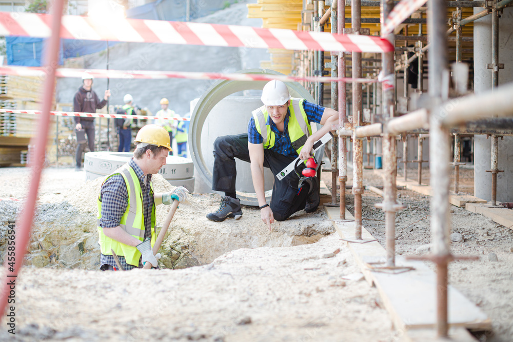 Construction workers using level tool at construction site Stock Photo ...