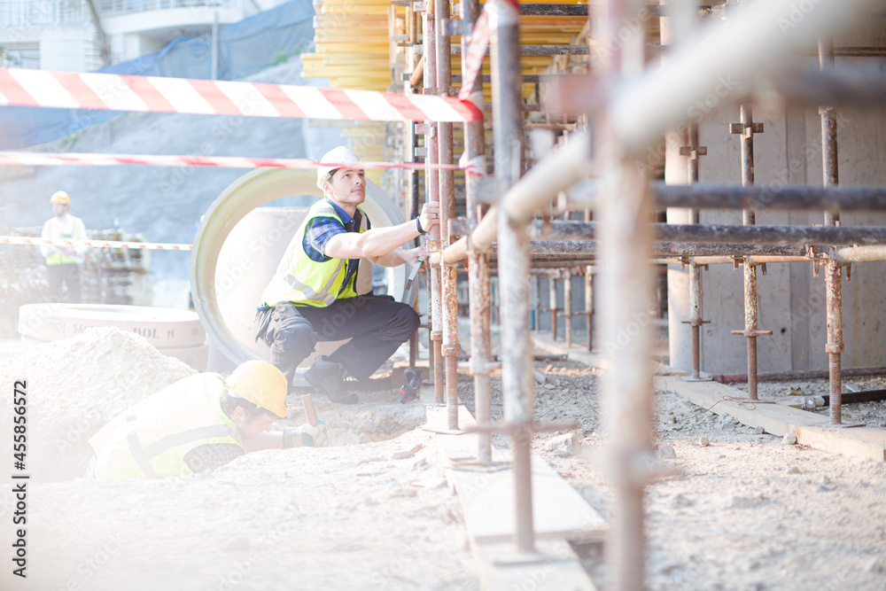 Construction workers using level tool at construction site Stock Photo ...