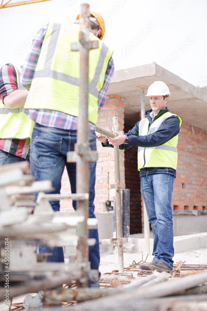 Constructor workers assembling rebar structure at construction site ...