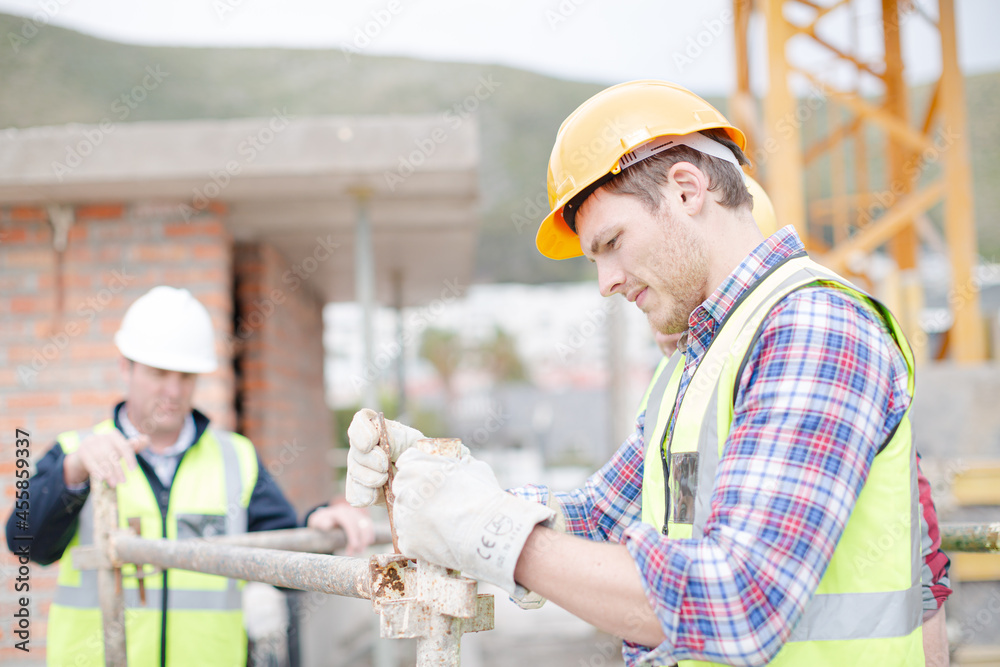 Constructor workers assembling rebar structure at construction site ...