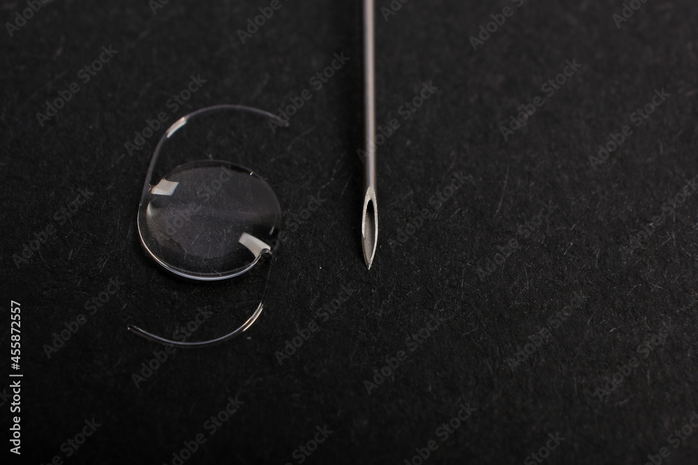 CLOSEUP PHOTO OF INTRAOCULAR LENS (IOL) FOR CATARACT SURGERY COMPARED ...