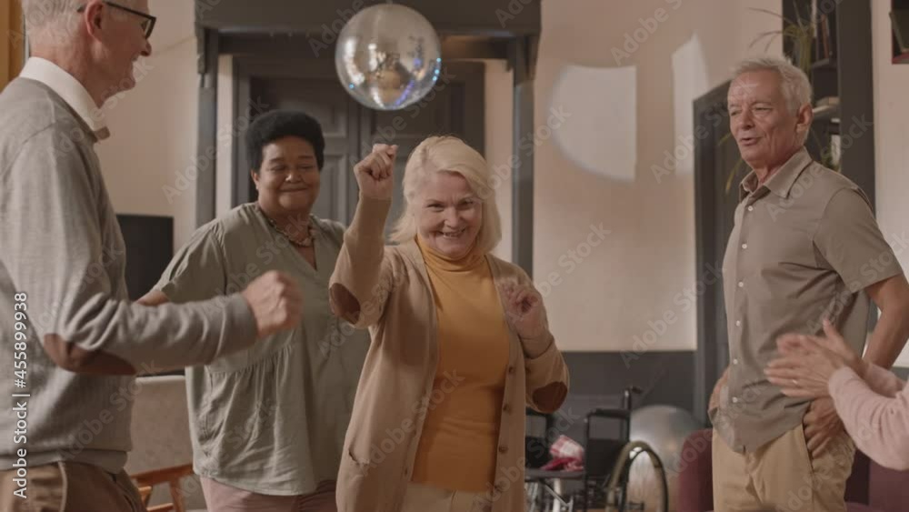 Slowmo medium shot of group of male and female seniors having fun ...