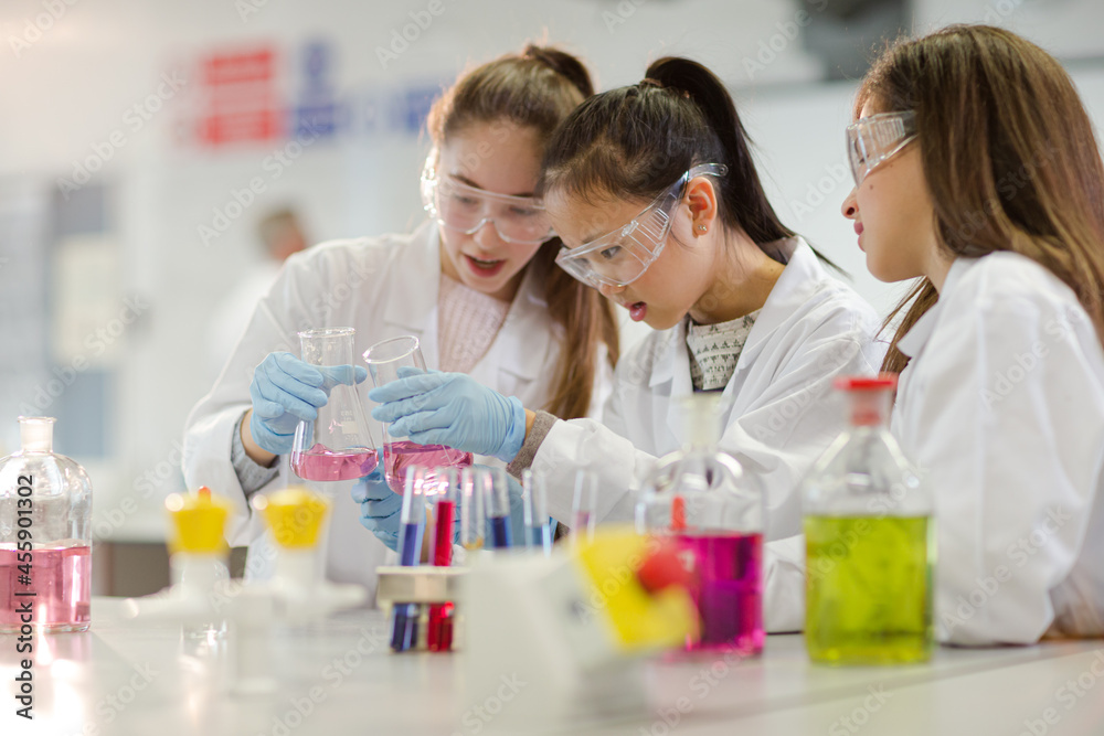Girl students conducting scientific experiment in laboratory classroom ...