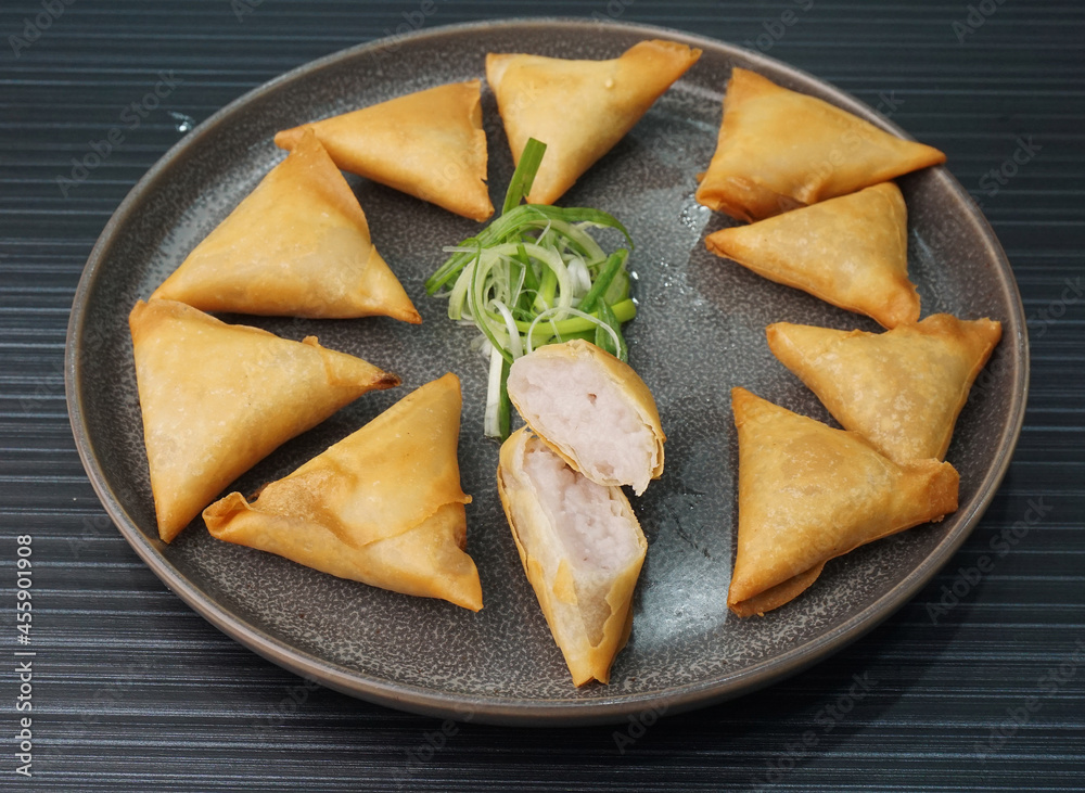 deep fried crispy yam taro spring roll samosa on dark grey wood ...