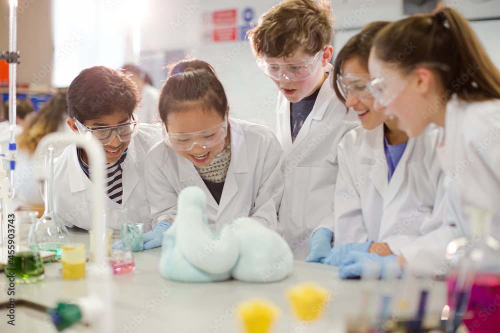 Surprised students conducting exploding foam scientific experiment in ...