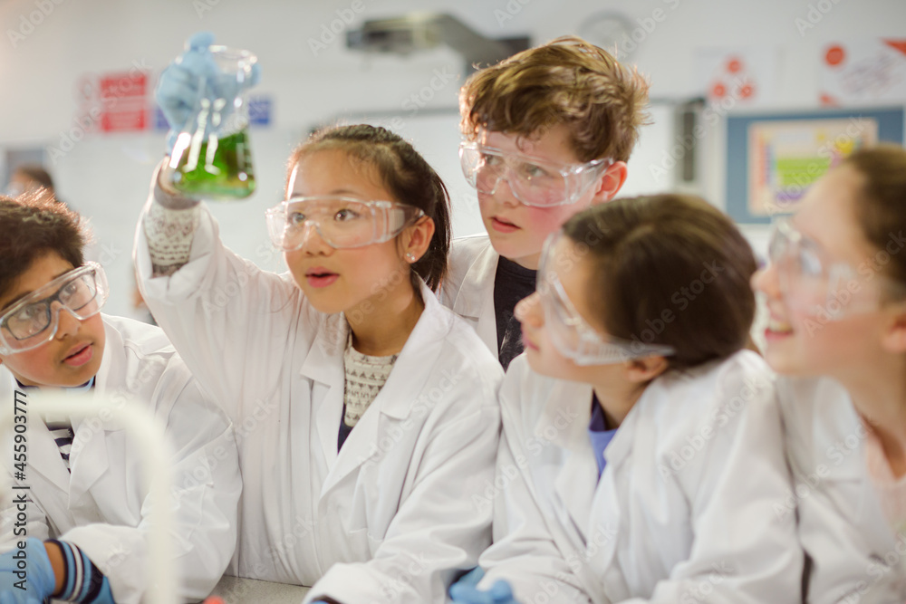 Curious students conducting scientific experiment, examining liquid in ...