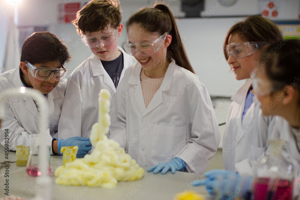 Surprised students conducting exploding foam scientific experiment in ...