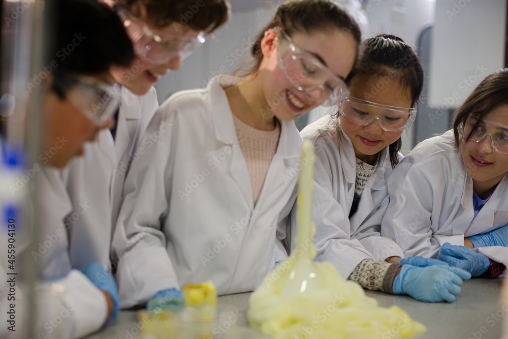 Surprised students conducting exploding foam scientific experiment in ...