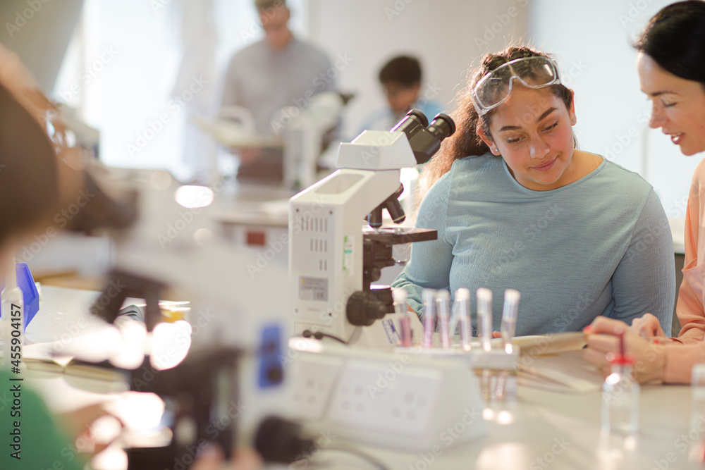 Female teacher and girl student conducting scientific experiment at ...