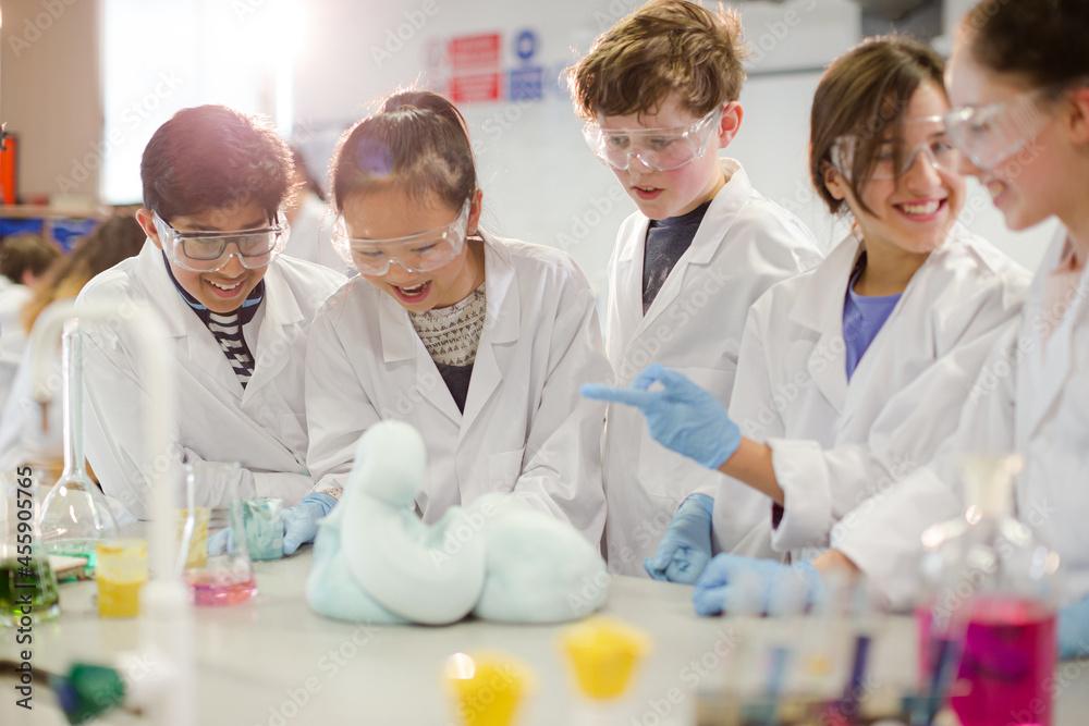 Surprised students conducting exploding foam scientific experiment in ...