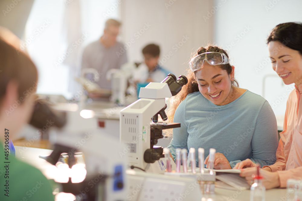Female teacher and girl student conducting scientific experiment at ...