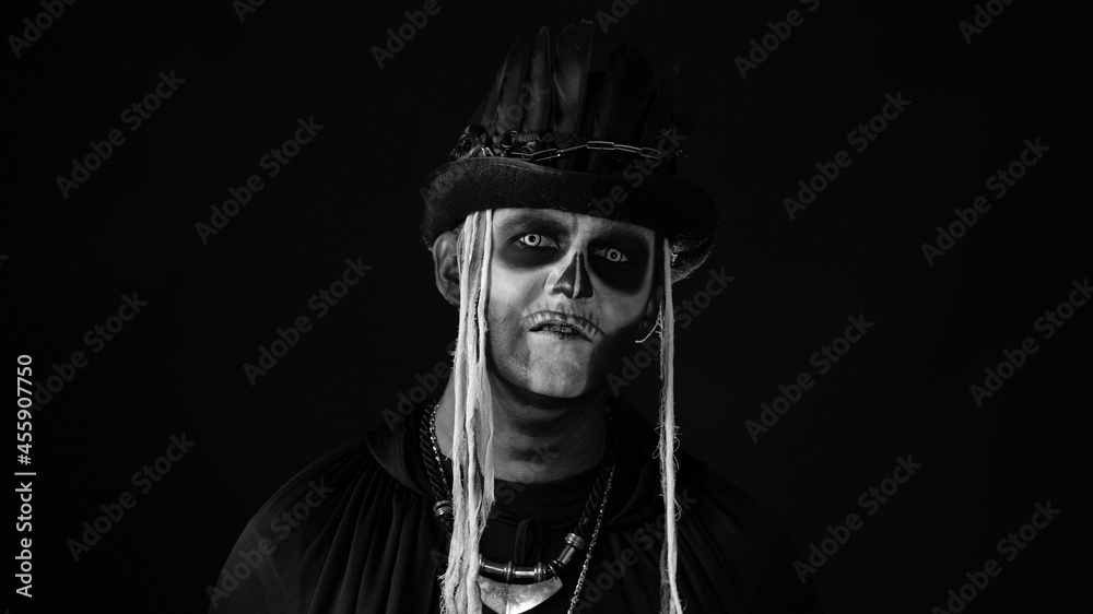 Sinister man, professional skull makeup making faces and ominously ...