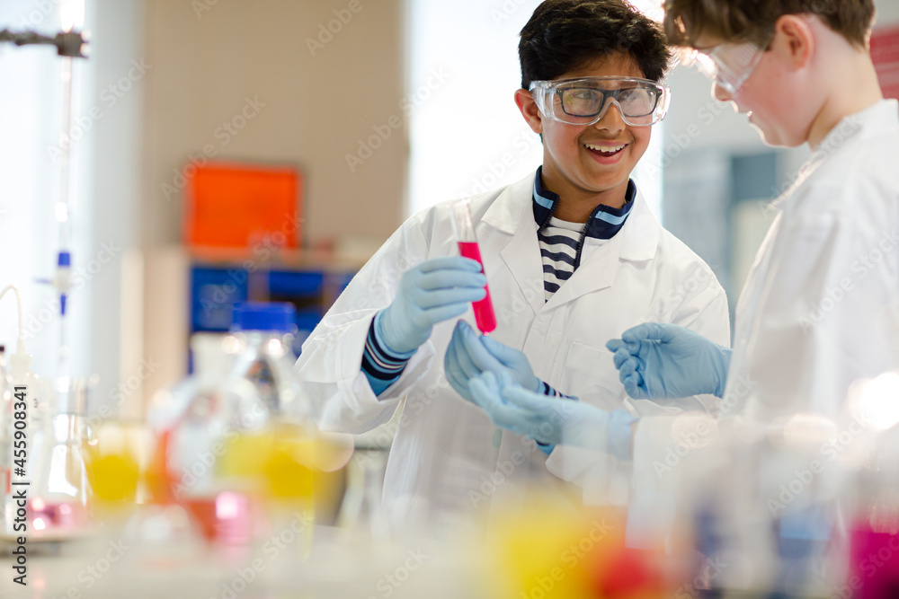 Boy students examining liquid in test tube, conducting scientific ...