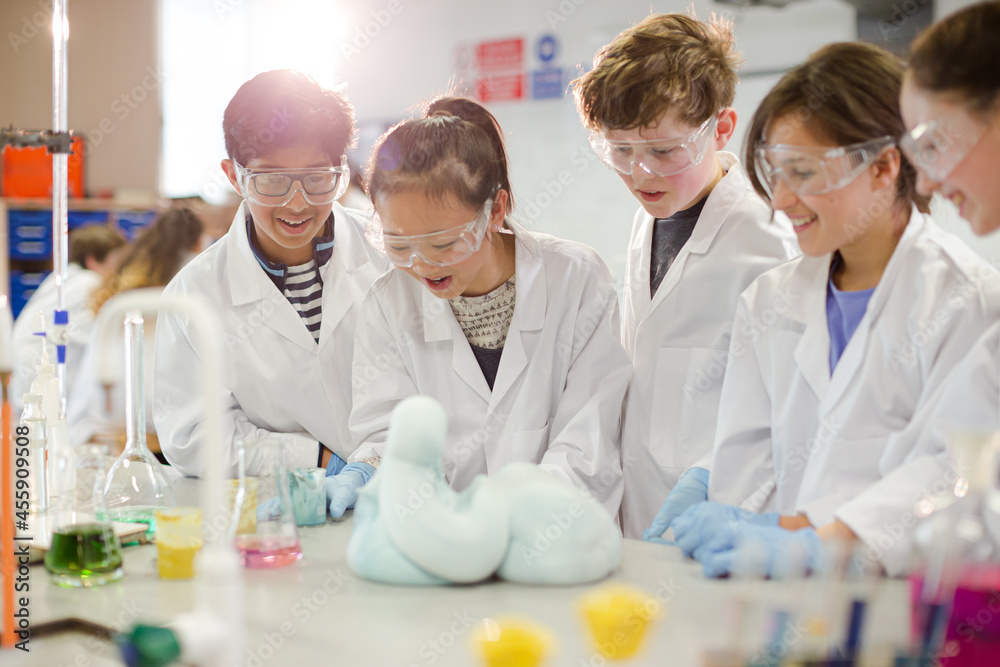 Surprised students conducting exploding foam scientific experiment in ...