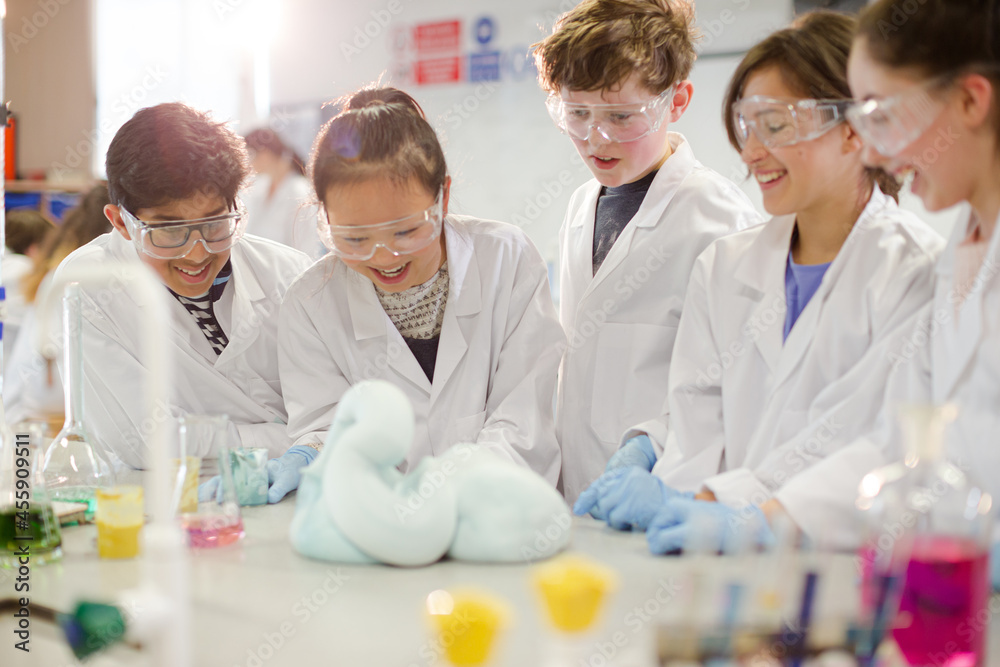 Surprised students conducting exploding foam scientific experiment in ...