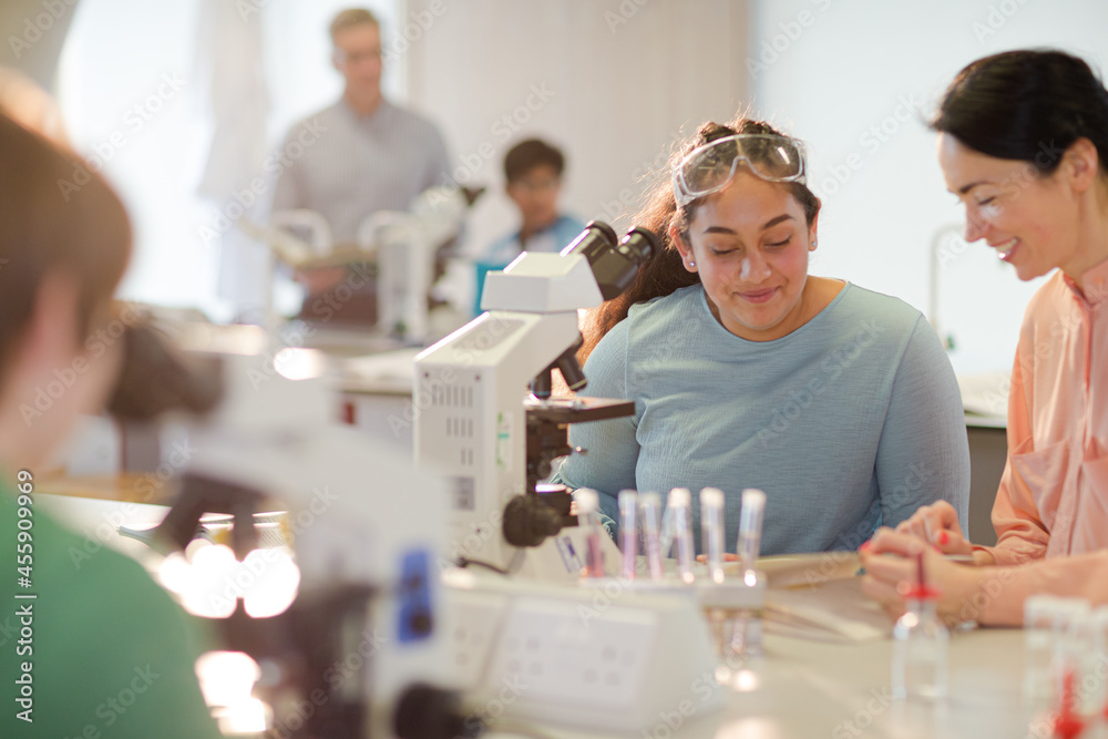 Female teacher and girl student conducting scientific experiment at ...