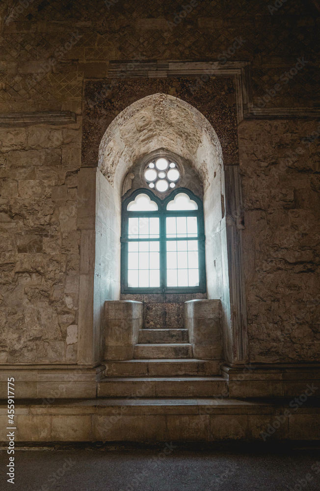 Vertical shot of the engraved arch window with stairs of Castel del ...