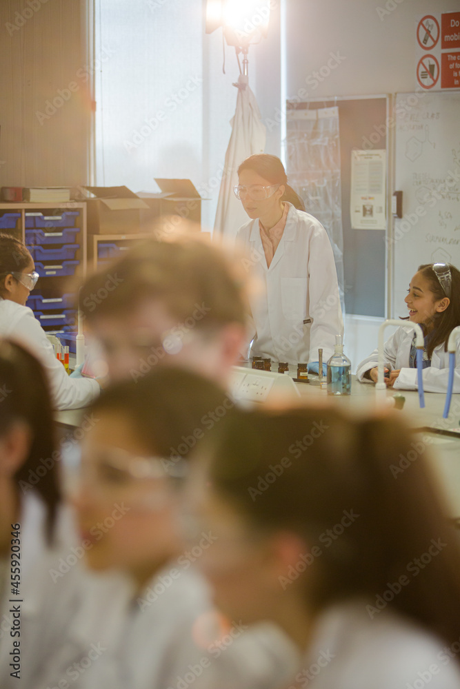 Female teacher and students conducting scientific experiment in ...
