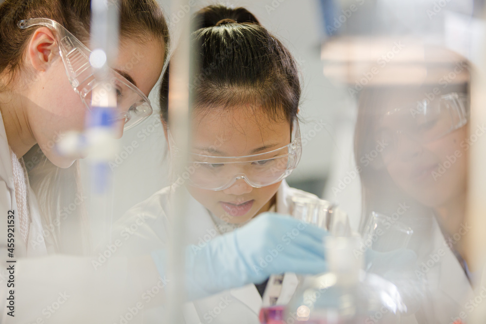 Girl student examining liquid in test tube, conducting scientific ...