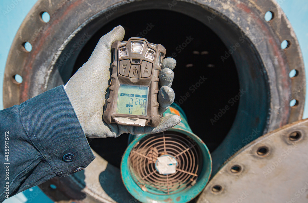 Worker hand holding gas detector inspection safety gas testing at front ...