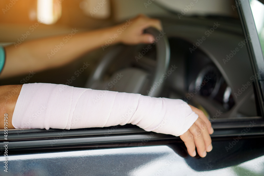 Concept : unsafe driving. Injured man with bandage on hand and arm is ...