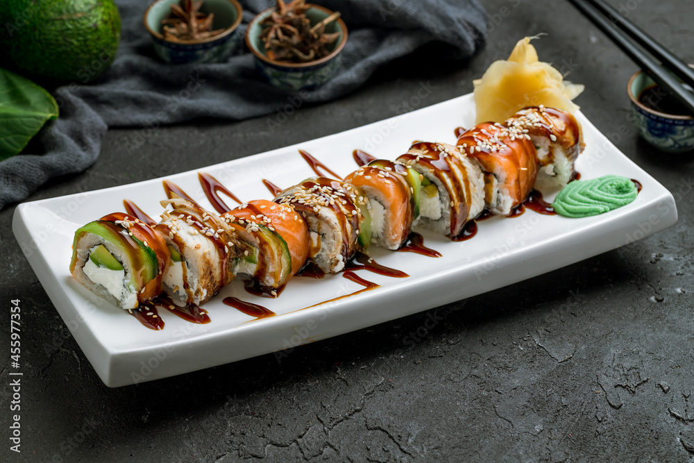 Philadelphia roll with eel and salmon and cream cheese on plate on dark ...