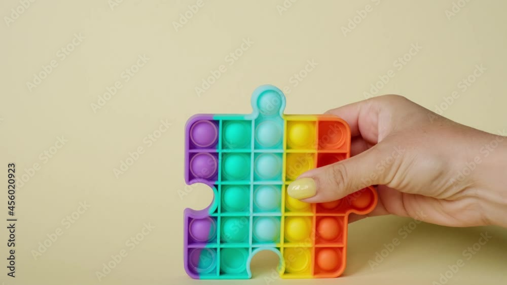 Popular modern rainbow-colored popit toy in the form of a puzzle in ...