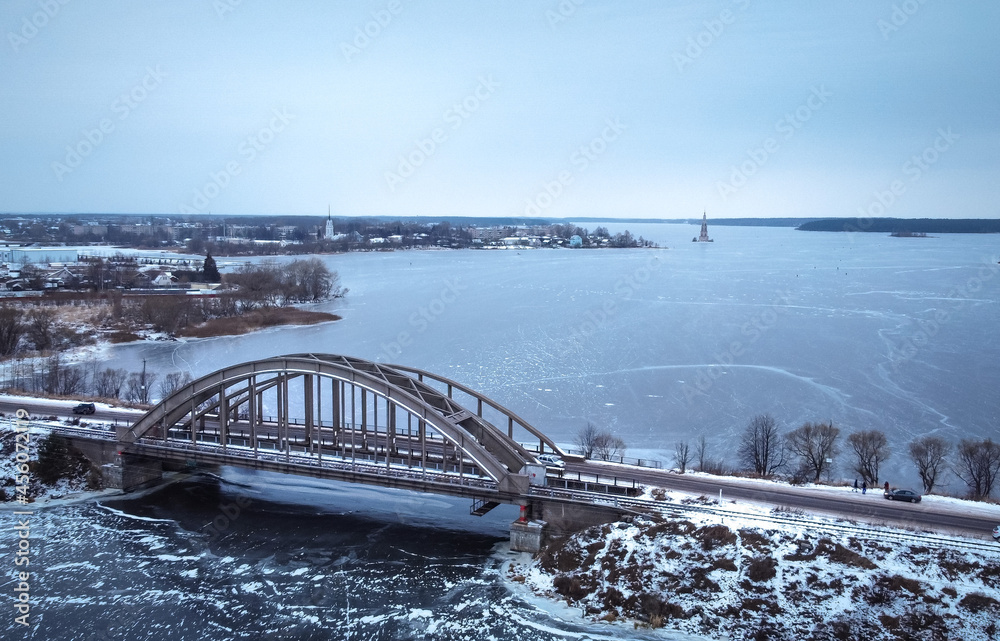 winter, iron bridge for cars and trains, over a frozen river ...