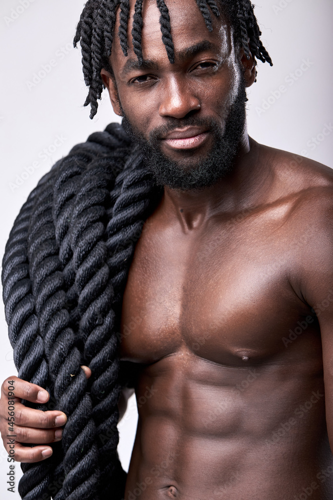 young sexy active african man going to train with battle ropes, keeping ...