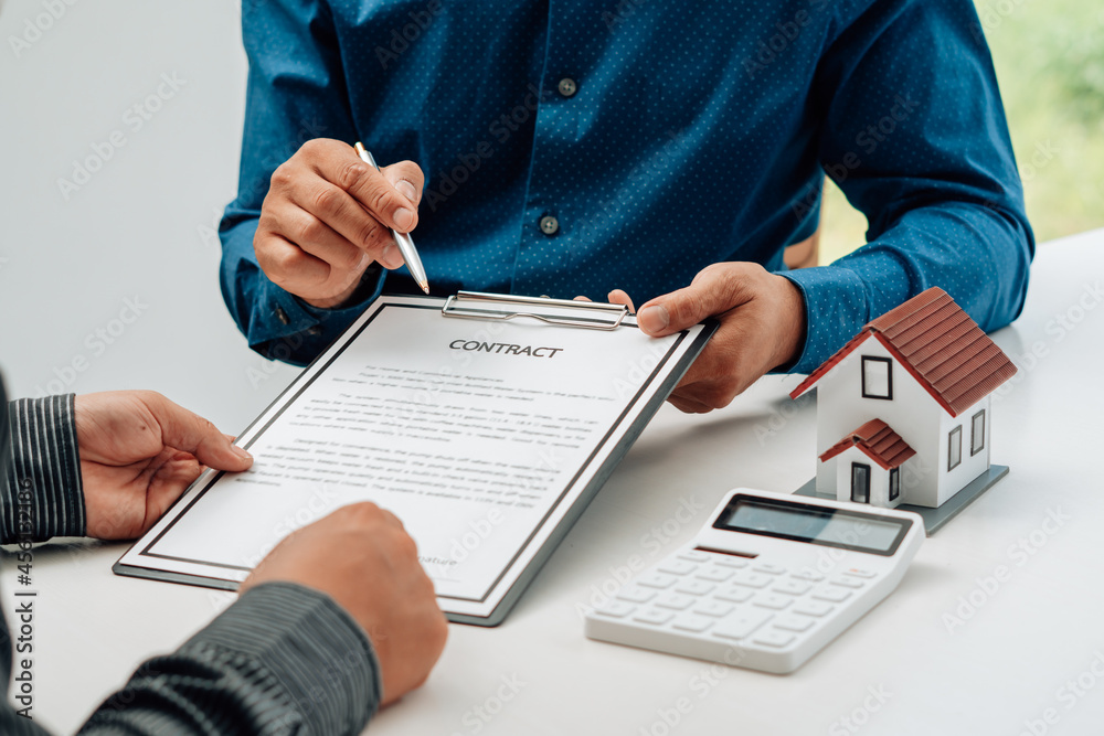 The real estate agent is explaining the house style to the clients who ...