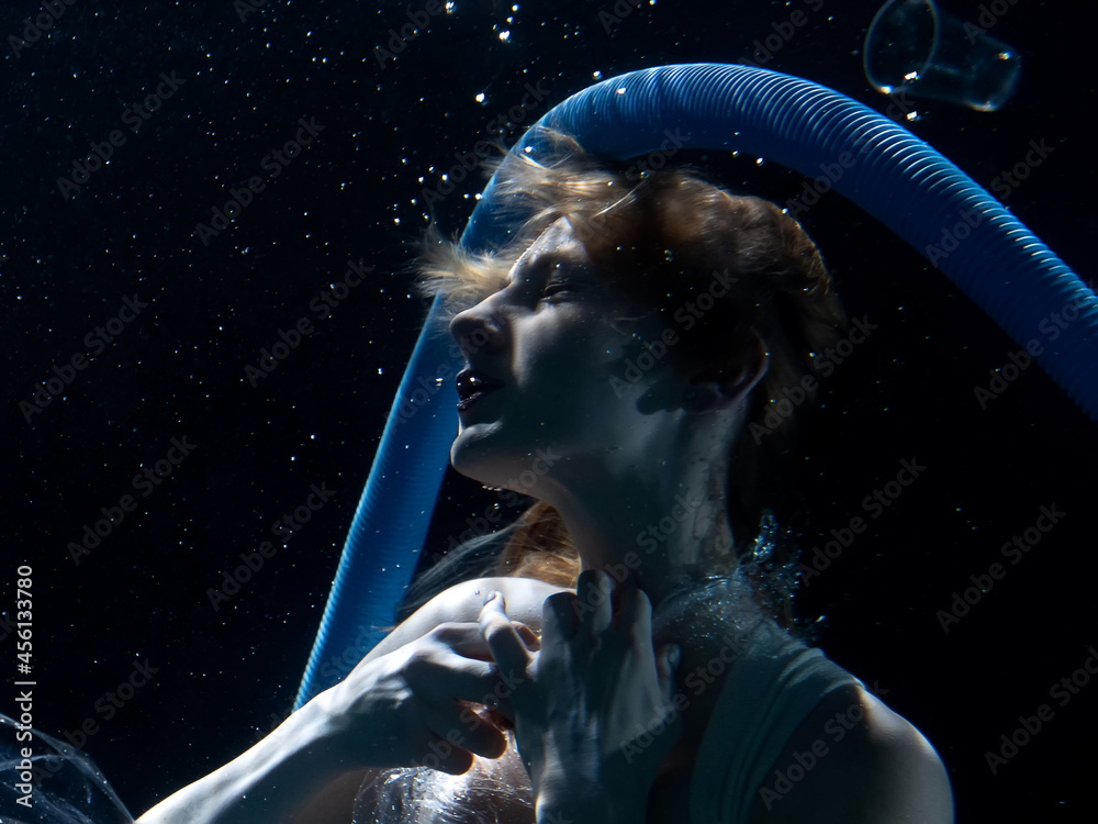 Woman swimming underwater among plastic trash. Girl drowning in sea ...