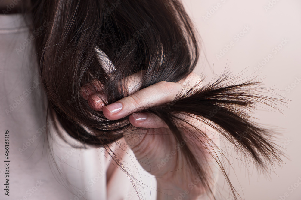 Hair care concept. Young woman with long split ended hair on pastel ...