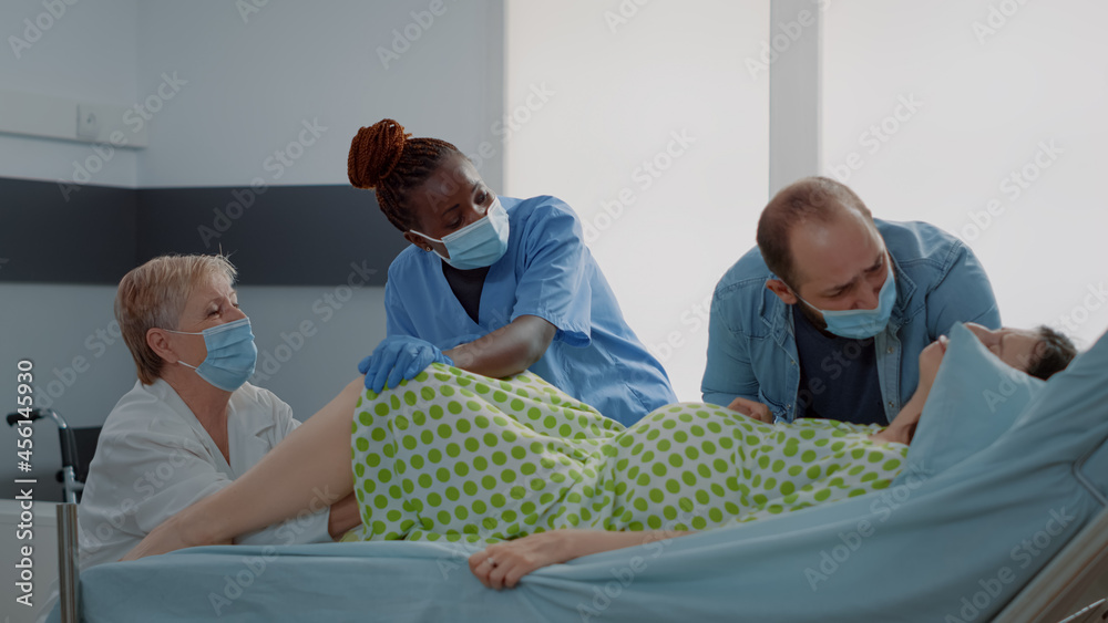 Multi ethnic medical team supporting woman giving birth at maternity in ...