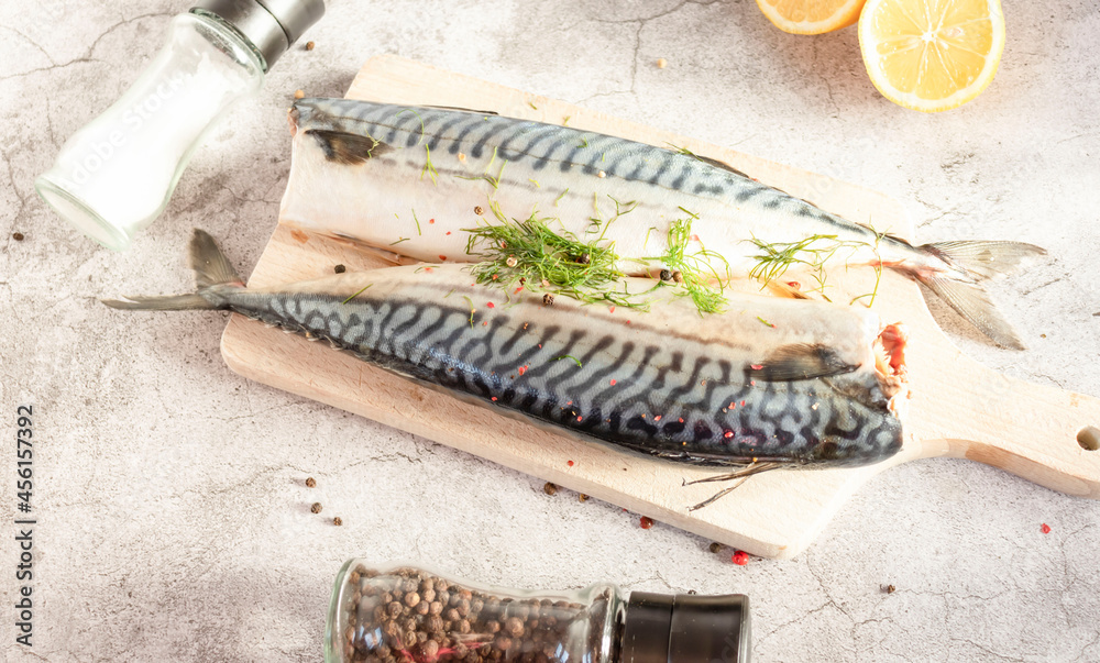 Fresh raw mackerel fish. On a gray background. Raw fish with lemon and ...