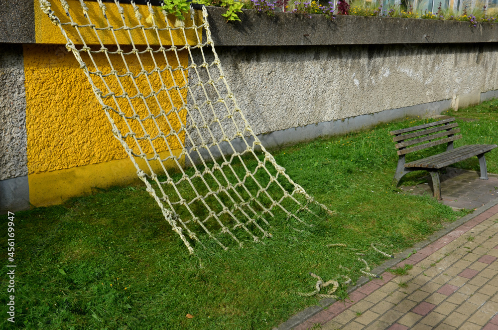 Stockfoto a rope net is attached to the concrete wall and is obliquely ...