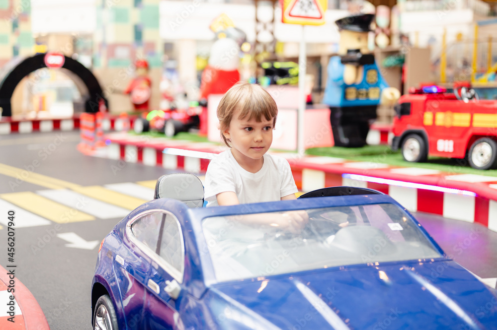 little happy four years old kid boy fun riding an small electric cars ...