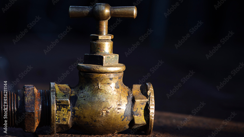 Vintage old brass water tap isolated on a dark background. tap valve ...
