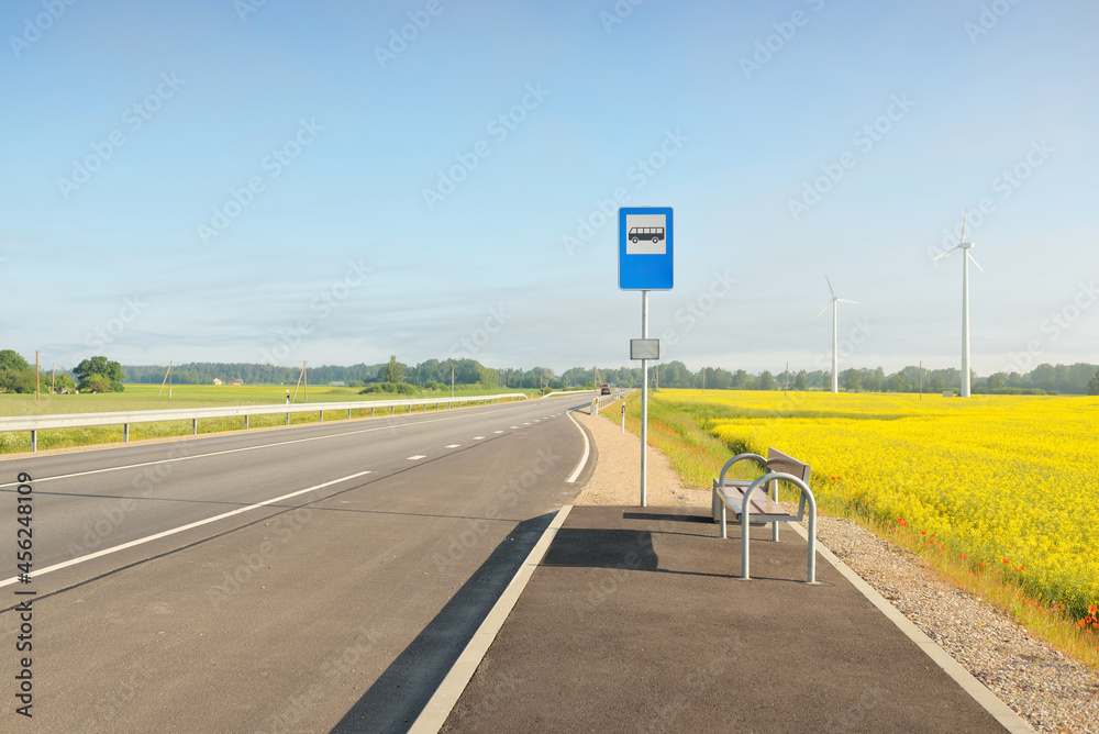 Bus stop and country highway (new asphalt road) through the green ...