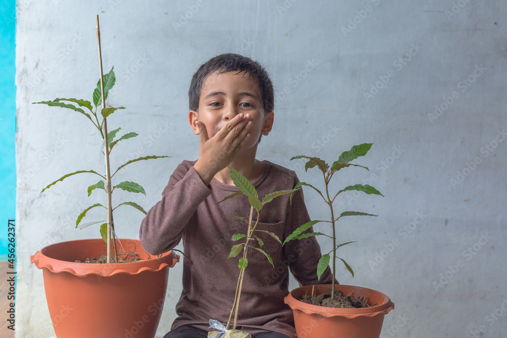 A happy boy enjoy with his Kratom tree seedlings. .A cute boy sat ...