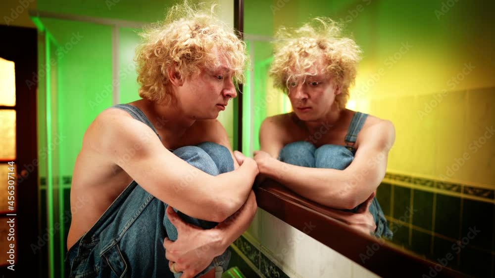 Depressed sad queer man crying sitting in bathroom thinking reflecting ...