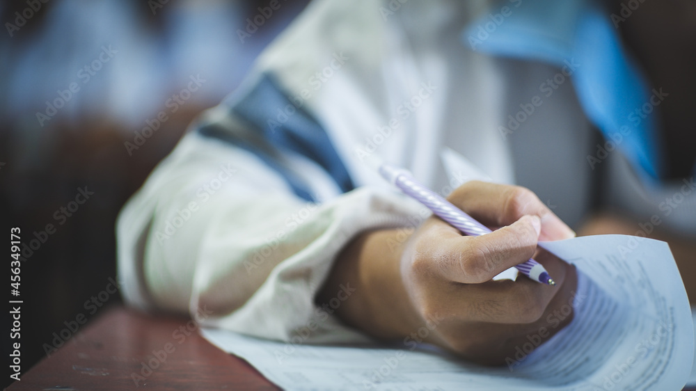 Students writing and reading exam answer sheets exercises in classroom ...