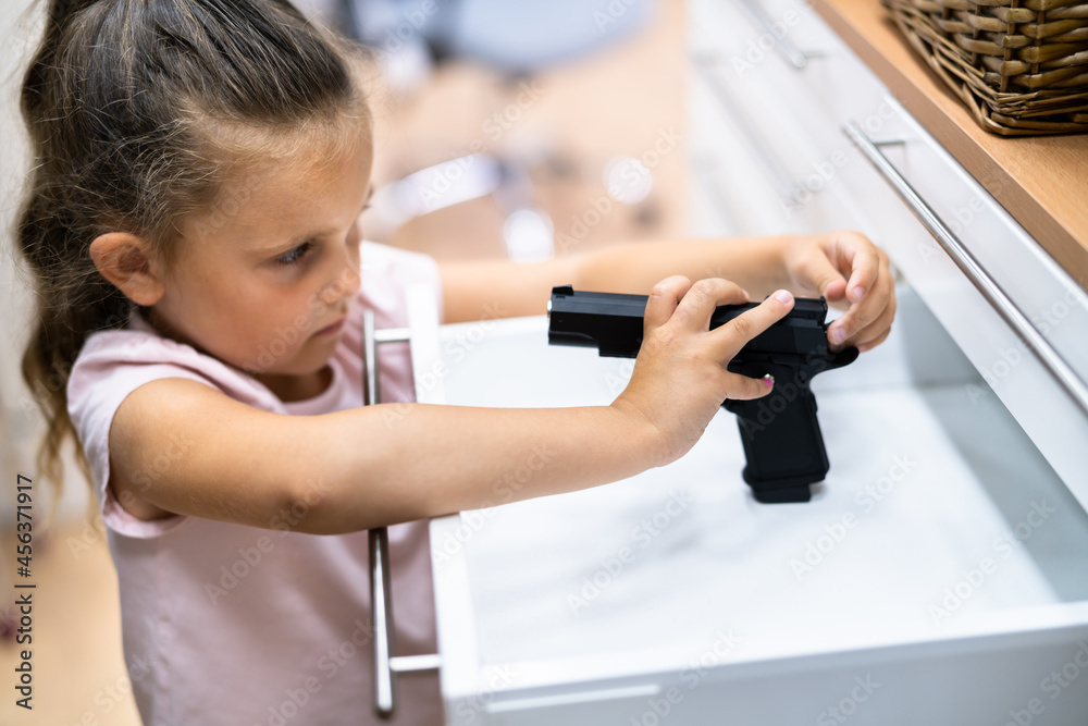Kid With Gun. Girl Reaching For Pistol In Drawer Stock Photo | Adobe Stock