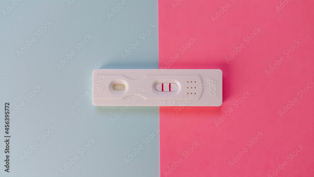 Foto Stock The hCG test lies on a blue and pink background and shows ...