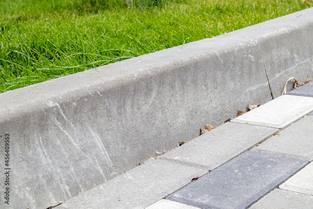 Installation of concrete curbs. Road infrastructure repair. Green grass ...