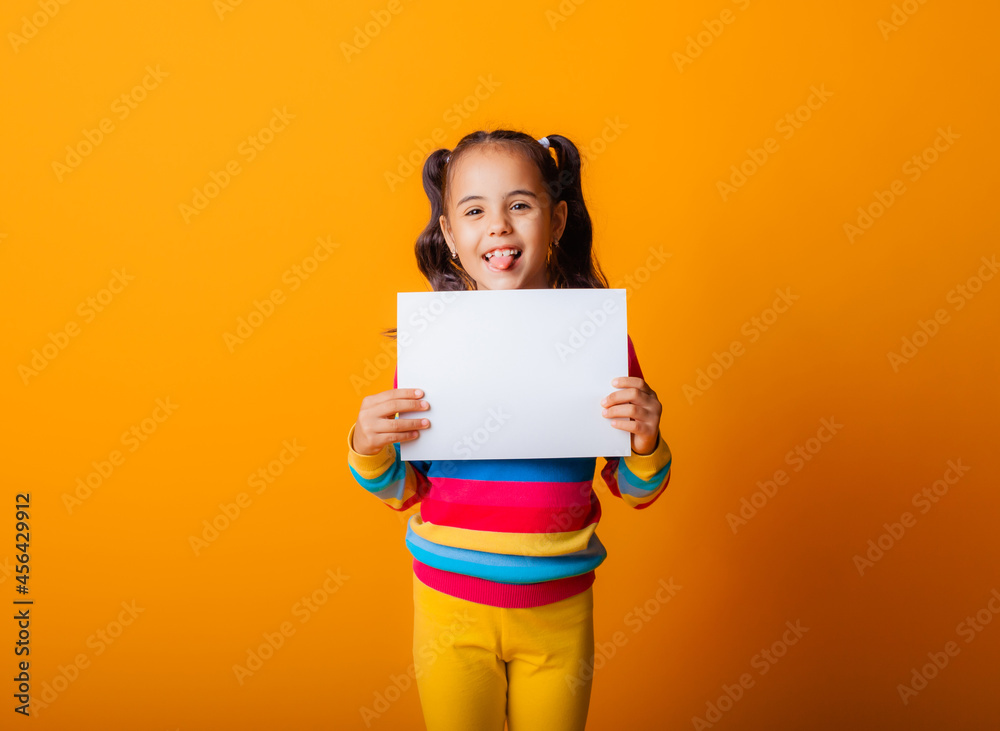 Cute little girl with a white sheet of paper. yellow background little ...
