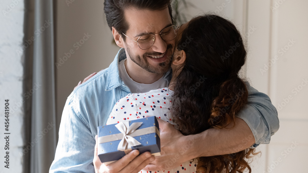 Happy husband hug wife feel grateful for gift box received, couple ...