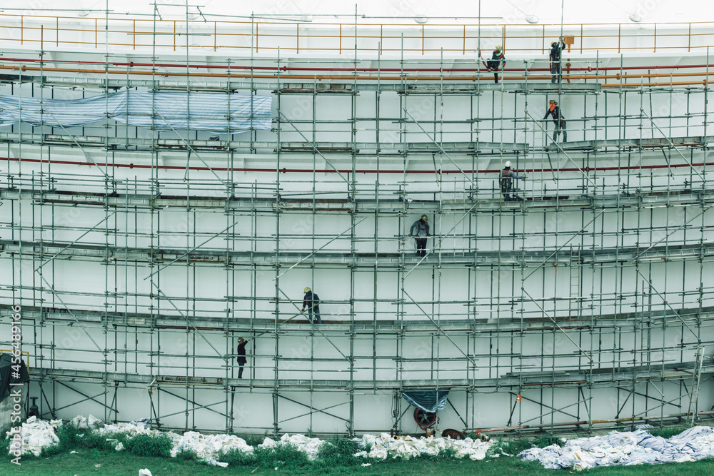 Architect on site construction workers on a scaffold tank oil ...