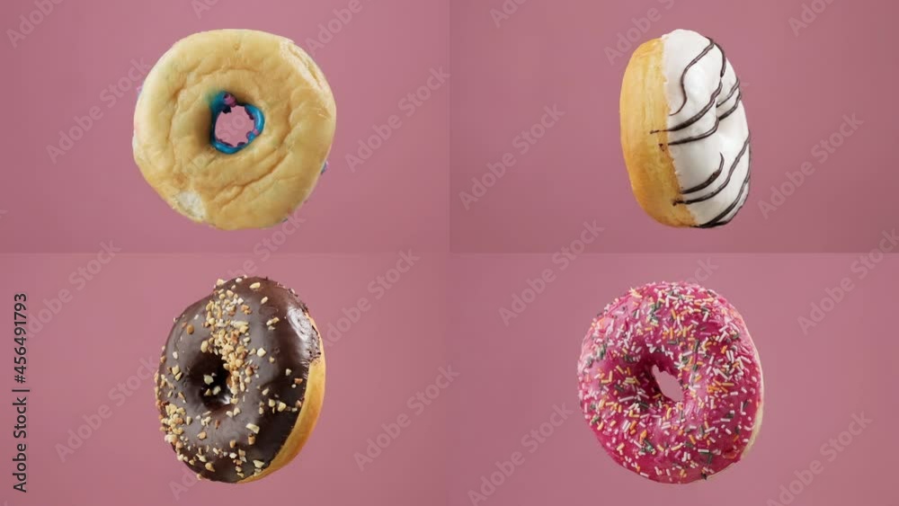 Various colorful donuts at pink background. Donuts of different colors rotating. Four glazed ...