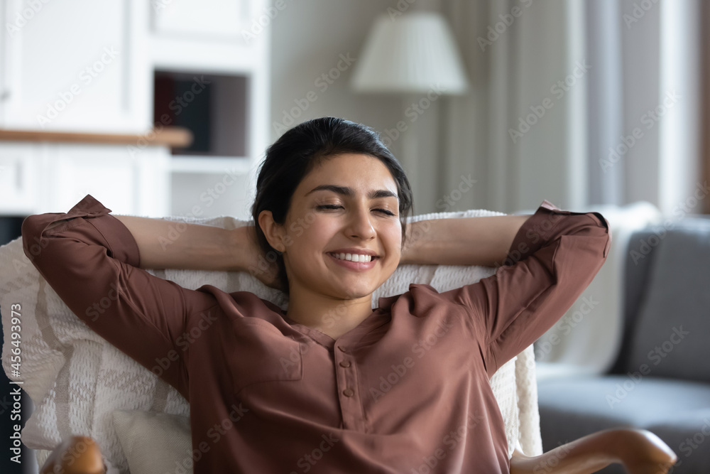 Chilling at home. Tranquil young indian female sit on comfy chair enjoy ...
